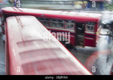 Blur night bus in rainy weather in Southeast Asia. A bunch of buses in ...
