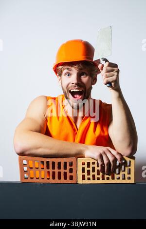 Crazy builder with bricks, funny sale on construction site. Funny man ...