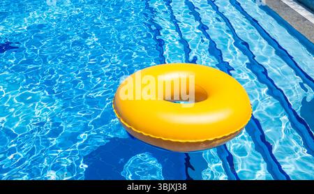 Inflatable yellow inner tube floating in clear blue waters with motion ...