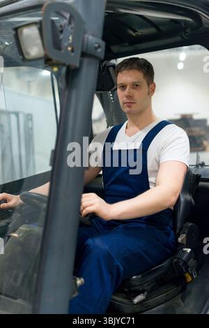 Handsome forklift operator working in the warehouse Stock Photo - Alamy