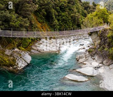 Aerial photograph of a suspension bridge at the Cesspool, Arahura River ...
