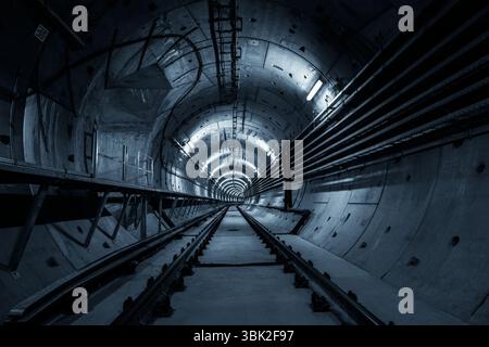 Underground tunnel for the subway leading deep down Stock Photo - Alamy