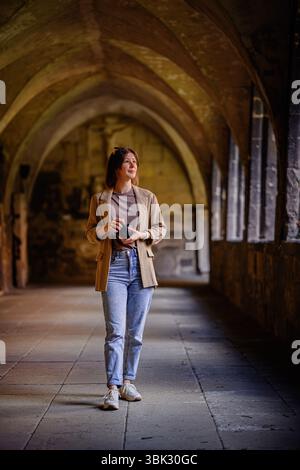Portrait of female photographer walking around city with professional ...