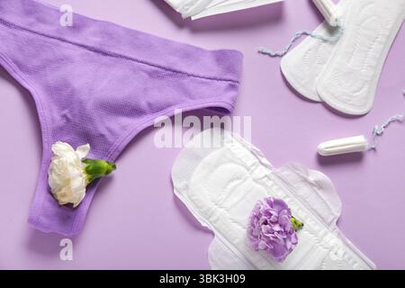 Menstrual pads with carnation flowers and underpants on purple ...