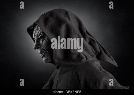 Scary figure with hooded cloak over dark misty background with clipping ...