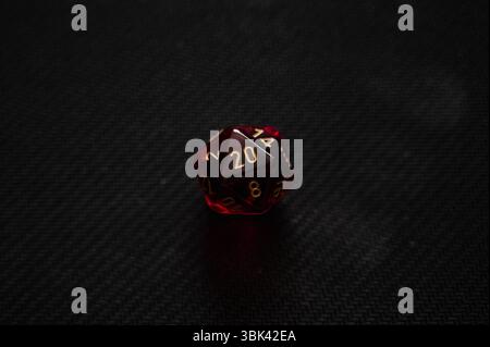 single red die showing the number one, isolated on a black background ...