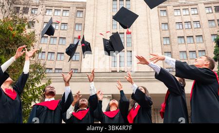 International group of students throwing graduation caps up Stock Photo ...