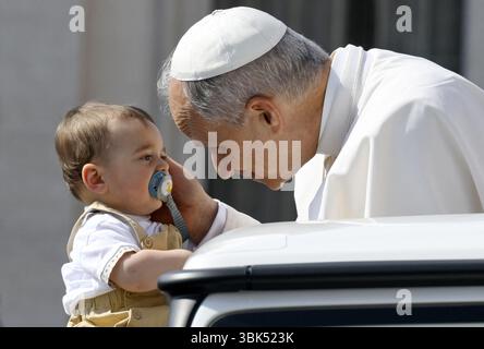 Pope Leo XIV greets a child as he arrives for his weekly general ...