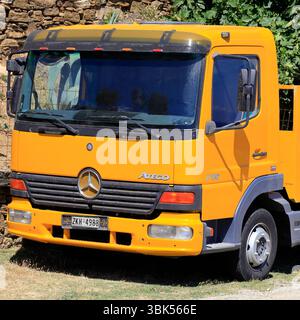 Yellow lorry parked by the roadside, Tinos, The Cyclades island group ...