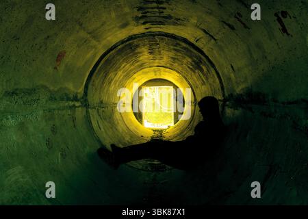 Man sitting in underground concrete tunnel angle shot Stock Photo - Alamy