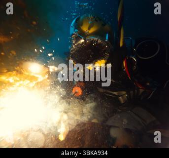 Commercial diver welding underwater at construction site Stock Photo ...
