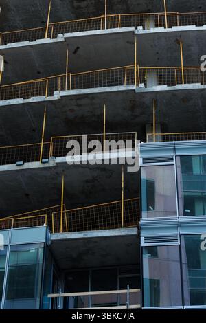 A concrete structure with blue scaffolding and exposed rebar, used for ...