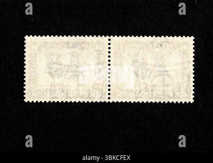 The backs of vintage postage stamps isolated on a black background ...