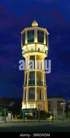 Octagonal tower building against a blue sky with a unique round metal ...