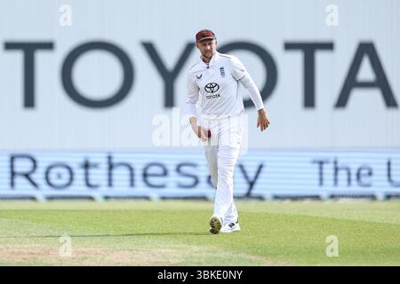 Joe Root of England (R) polishes the ball fro James Anderson of England ...