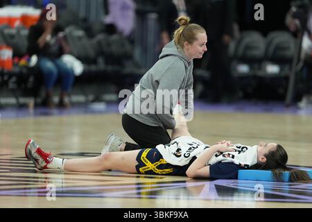 Indiana Fever guard Caitlin Clark, right, sits on the bench with ...