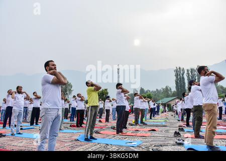 Srinagar, India. 21st June, 2025. Participants perform yoga during a ...