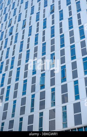 A detailed view of a building facade featuring a repetitive pattern of ...