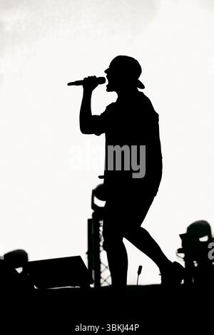 Silhouette of singing young man with microphone on white background ...