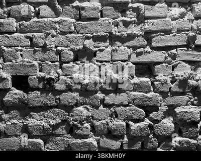 Old and cracked, dilapidated and uneven brick wall with yellowed ...