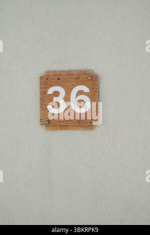 House number 36 on a natural grained and varnished wooden door with ...