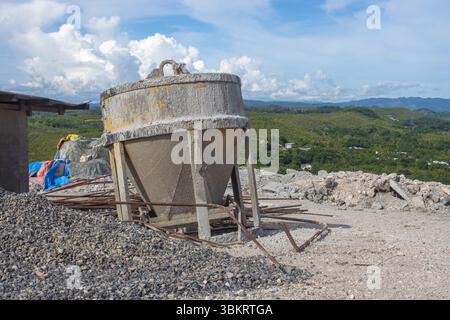 Heavy-duty concrete pouring bucket hanging in mid-air over scaffolding ...