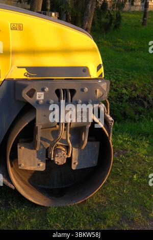 Yellow drum roller machine vehicle parking in the middle of city park ...