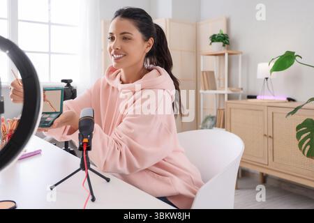 Female beauty blogger with eyeshadows recording video at home Stock ...