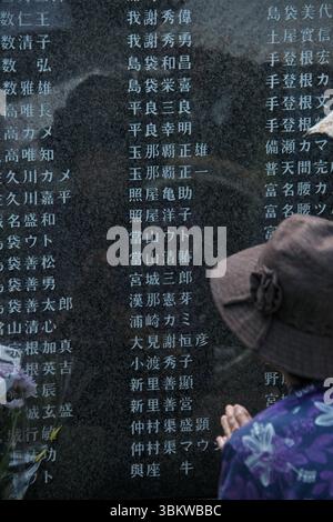 A bereaved family prays for victims at the Peace Memorial Park in ...