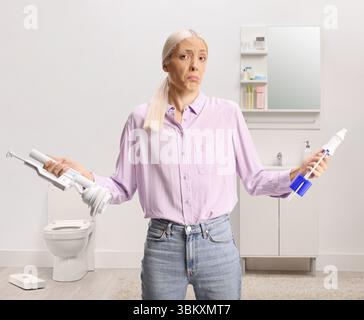 Woman holding toilet tank components in a bathroom Stock Photo - Alamy