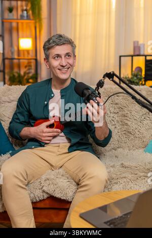 A man plays the ukulele guitar in nature, blurred background Stock ...