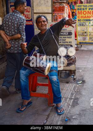 India, Delhi, 25 Jun 2025. Street musician carrying traditional Indian ...