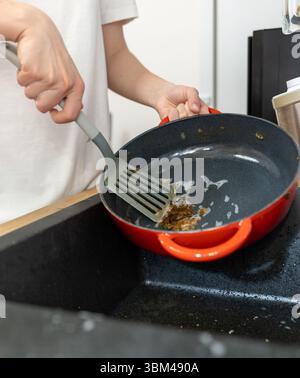 hands wash pan with burnt food with metal sponge Stock Photo - Alamy