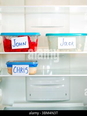 Meal containers labeled with employee names in clean office ...