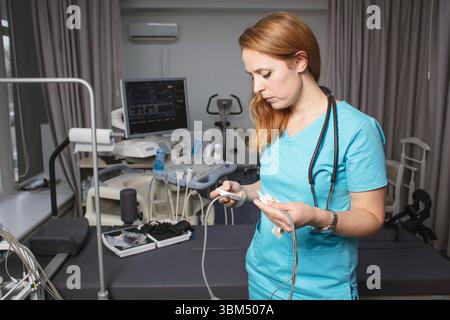 Doctor showing ECG holter monitor to patient in pediatric clinic ...