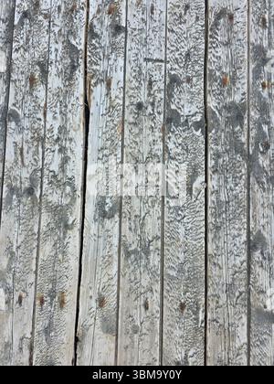 Weathered vertical wooden deck planks with screws and prominent grain ...
