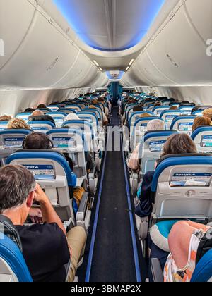Airplane interior with rows of seated airline passengers from Dubai,UAE ...
