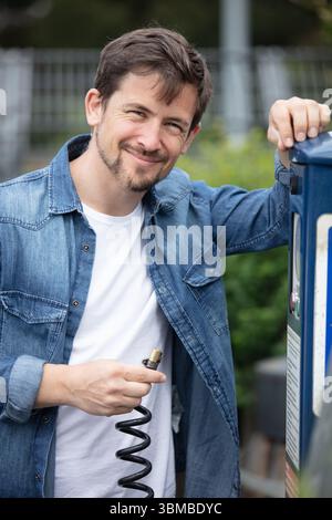 asian business man pumping air into car Stock Photo - Alamy