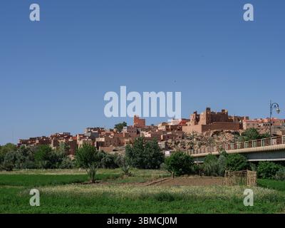 Sunlit adobe buildings with a clear blue sky in a narrow alleyway ...