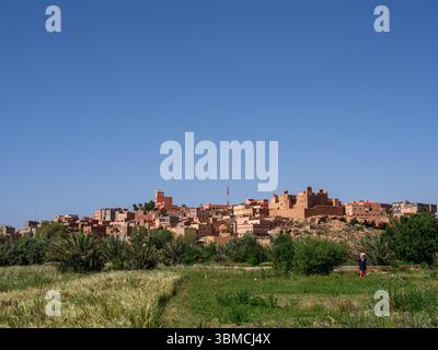 Sunlit adobe buildings with a clear blue sky in a narrow alleyway ...