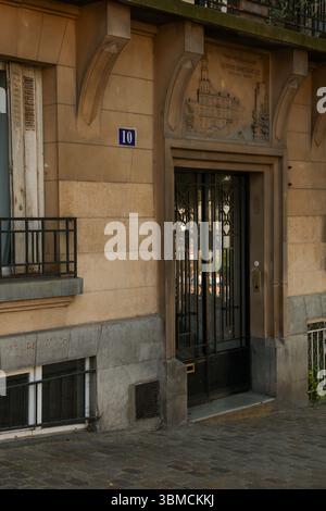 A low angle shot of beige stone building with vertical water pipe ...