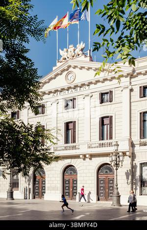 A vertical view of flags waving in the wind in a park of Pecs, Hungary ...