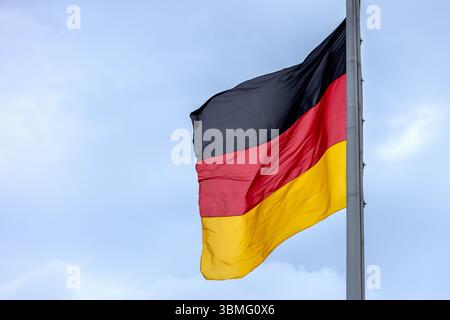 Deutschland Flagge Die deutsche Fahne weht im Wind unter einem dunklen ...