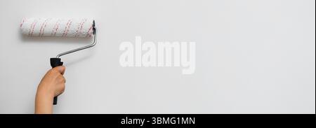 Woman's hand with white brush applying pink paint on wooden furniture ...