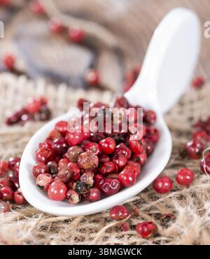 Portion of Pink Peppercorns as detailed close up shot on a slate slab ...
