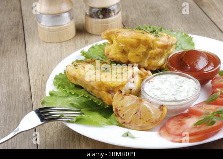 A closeup of fried fish with greens served on a plate Stock Photo - Alamy