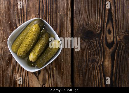 Preserved Gherkins (on wooden background) as detailed close-up shot ...