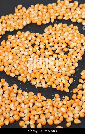 Yellow corn grains with a black background forming a heart drawing ...