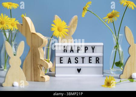 Happy Easter text on Lightbox with bunny wooden figures and fresh ...