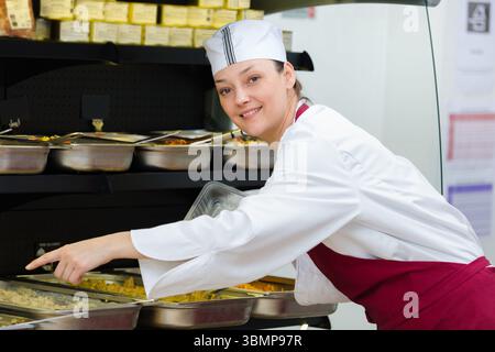buffet female worker servicing food in cafeteria Stock Photo - Alamy